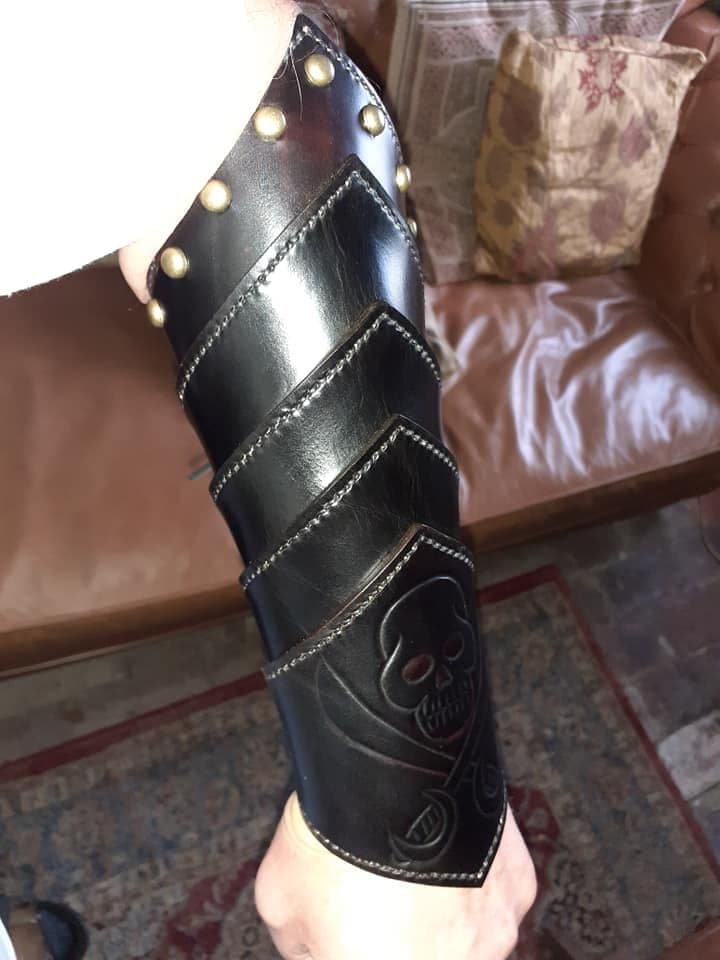 Black studded segmented gauntlet with pirate skull and cross swords ...